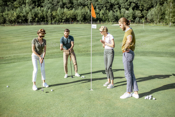 People playing golf outdoors Stock Photo by RossHelen | PhotoDune
