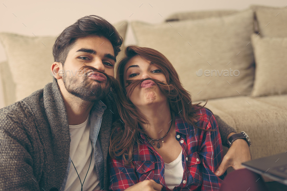 Couple making funny faces while taking photos Stock Photo by ...