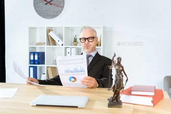 mature lawyer reading documents at modern workplace Stock Photo by ...