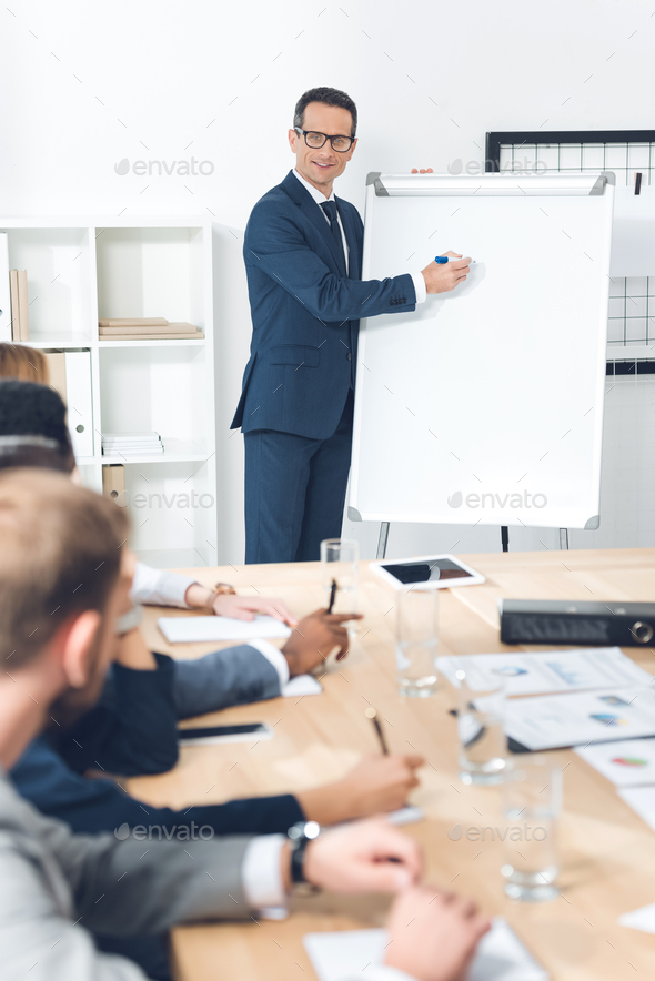 smiling mature businessman giving presentation at conference hall Stock ...