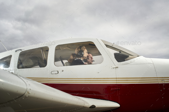 Plane in flight. Female flight instructor giving flight lessons to a ...
