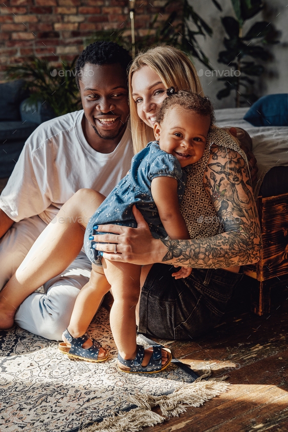 Mixed race family posing together on camera inside room Stock Photo by ...