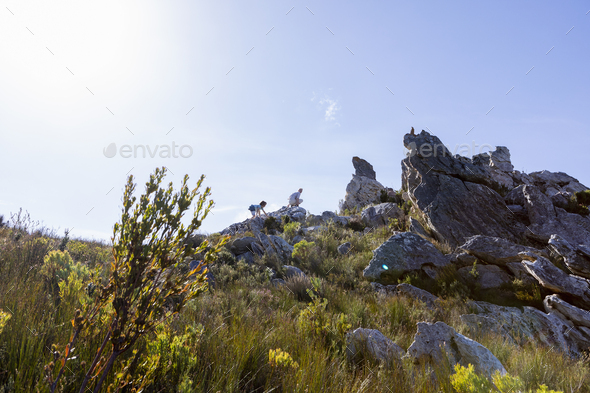 Two children climbing on top of large sandstone rock formations on a ...