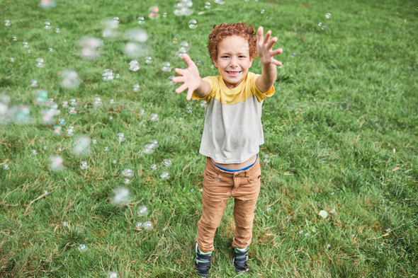 Boy Catching Bubbles in Park Stock Photo by seventyfourimages | PhotoDune