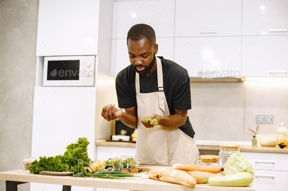 African-american man cooking in a kitchen Stock Photo by prostooleh