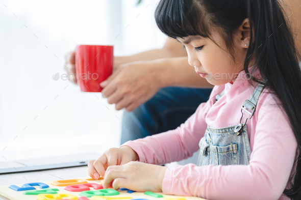Cheerful and playful cute little girl learning numbers and math with ...