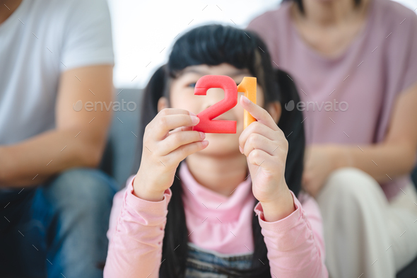Cheerful and playful cute little girl learning numbers and math with ...