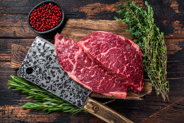 Raw denver cut black angus beef steak on a butcher board with meat ...