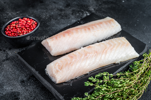 Raw cod loin fillet fish on marble board. Black background. Top view ...
