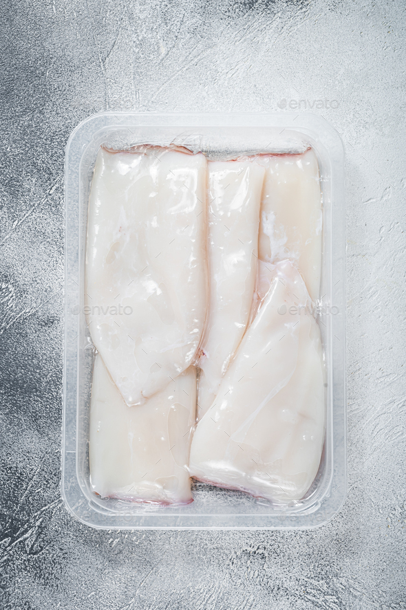 Fresh Raw Squid or Calamari in a vacuum package on a kitchen table ...
