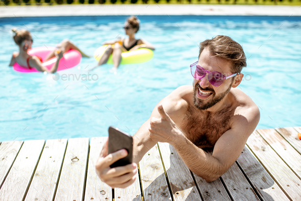 Man with phone in the swimming pool Stock Photo by RossHelen | PhotoDune