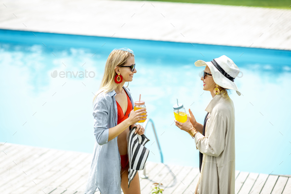 Girlfriends on the swimming pool outdoors Stock Photo by RossHelen