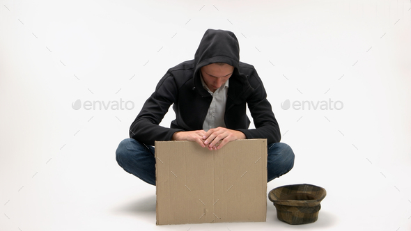 Poor sad man with blank cardboard sign. Stock Photo by stockfilmstudio