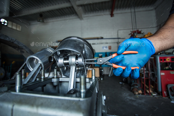 Mechanic fixing a compressor engine Stock Photo by ADDICTIVE_STOCK