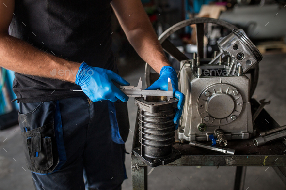 Mechanic fixing a compressor engine Stock Photo by ADDICTIVE_STOCK
