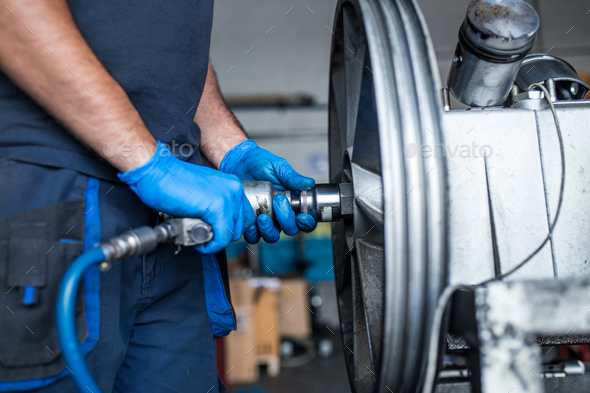Mechanic fixing a compressor engine Stock Photo by ADDICTIVE_STOCK