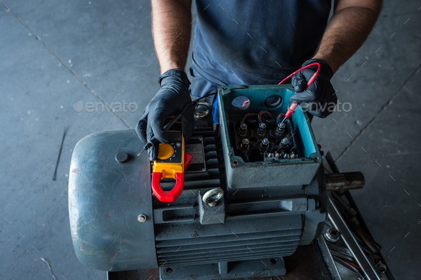 Mechanic fixing a compressor engine Stock Photo by ADDICTIVE_STOCK