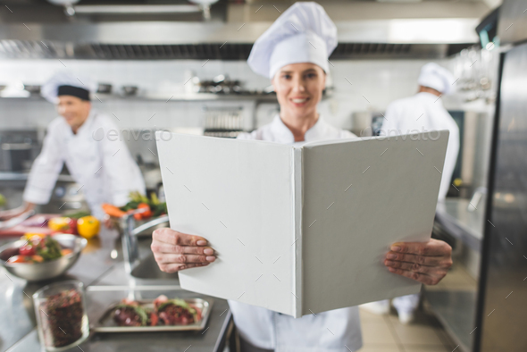 smiling chef holding recipe book at restaurant kitchen Stock Photo by ...