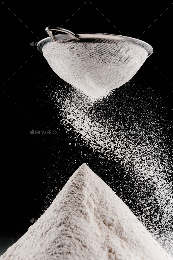 flour falling from sieve on pile isolated on black Stock Photo by ...