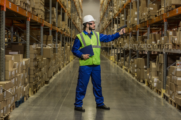 Man checking cargo on shelves with scanner Stock Photo by a_medvedkov