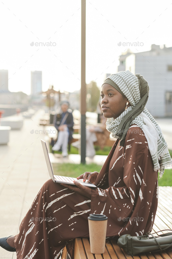 Muslim woman working on laptop outdoors Stock Photo by AnnaStills ...
