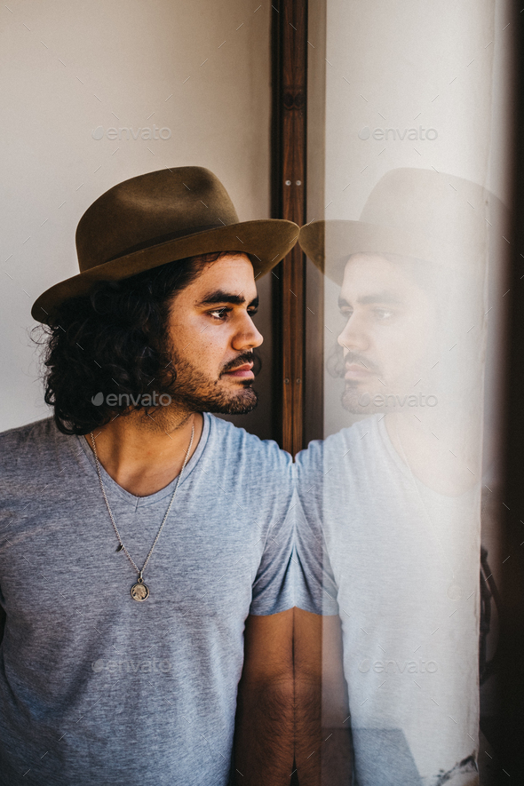 Handsome bearded man in hat looking in window Stock Photo by ADDICTIVE ...
