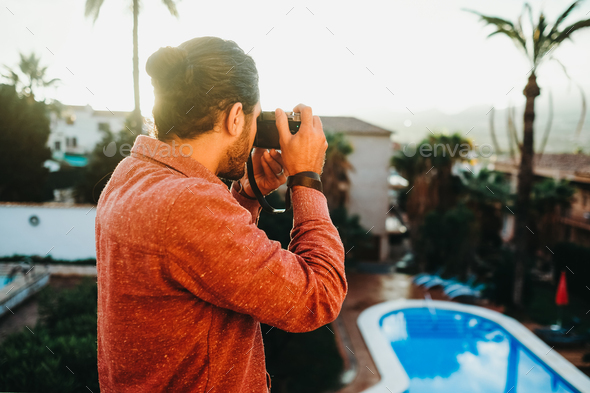 back view of a Man with photo camera on balcony in sunlight Stock Photo ...