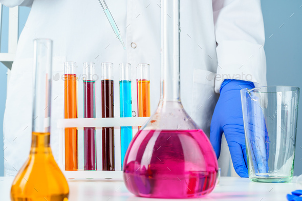 Colored liquids inside lab glassware on white table in laboratory Stock ...