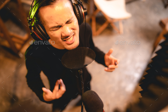 singer wearing earphones working to record and performance a music ...