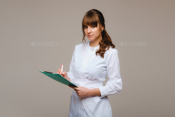 Portrait of a female medical worker in a gray background with a medical ...