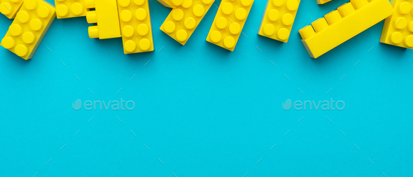 Yellow Plastic Building Blocks On Turquoise Blue Background With Copy ...