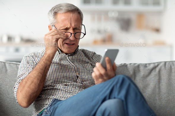 Senior Man Squinting Eyes Reading Message Wearing Eyeglasses At Home ...