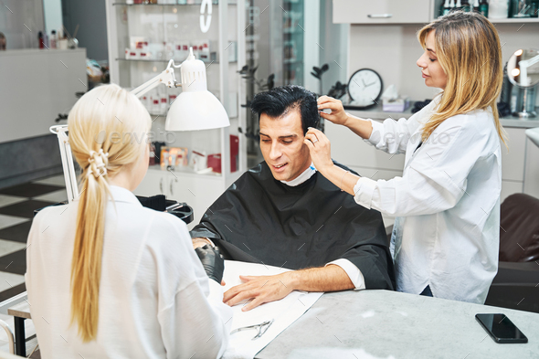 Beauty salon workers providing nail care and haircut Stock Photo by ...