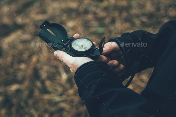 Man holding a compass in the mountain Stock Photo by ADDICTIVE_STOCK