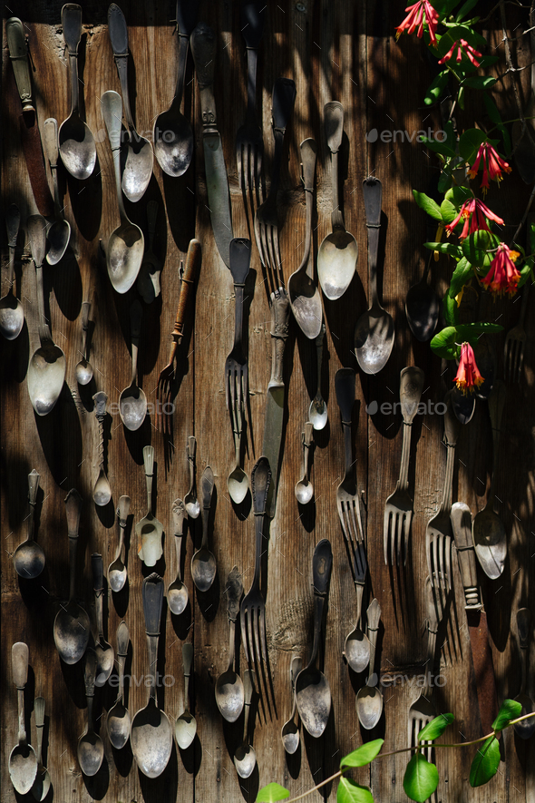 Old flatware hanging on wooden wall Stock Photo by ADDICTIVE_STOCK