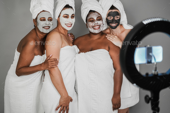 Multigenerational women wwearing face beauty masks while streaming live ...