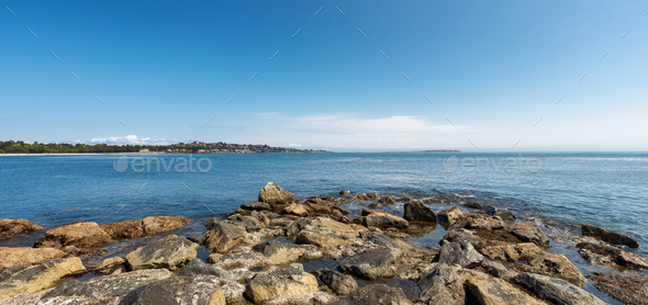 View of Rocky shore with birds at a modern city park, Clover Point ...