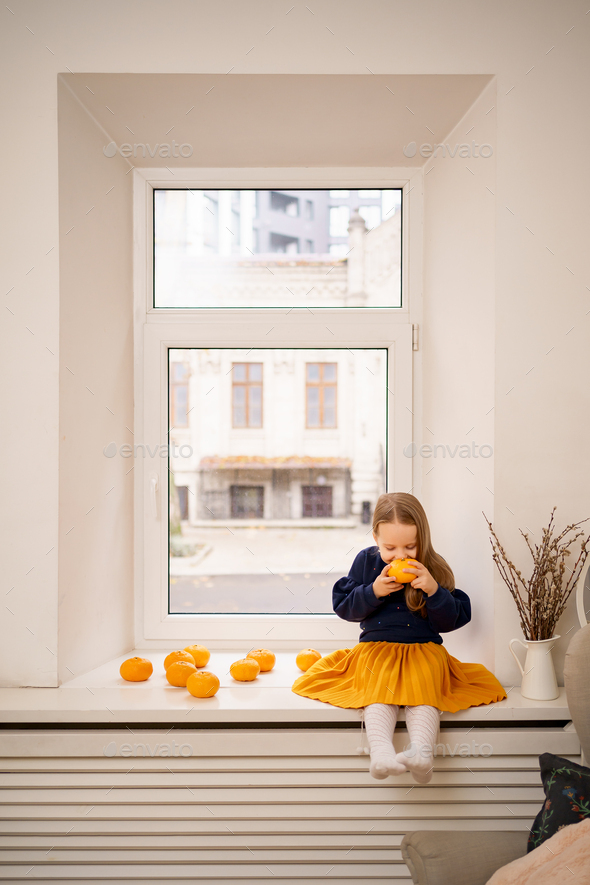 Lovely little girl sitting on the window Stock Photo by diignat | PhotoDune