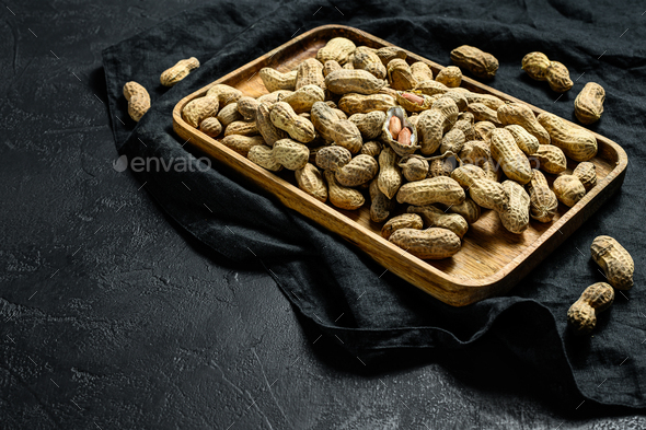 Raw unshelled peanuts in the shell. Organic groundnut. Black background ...