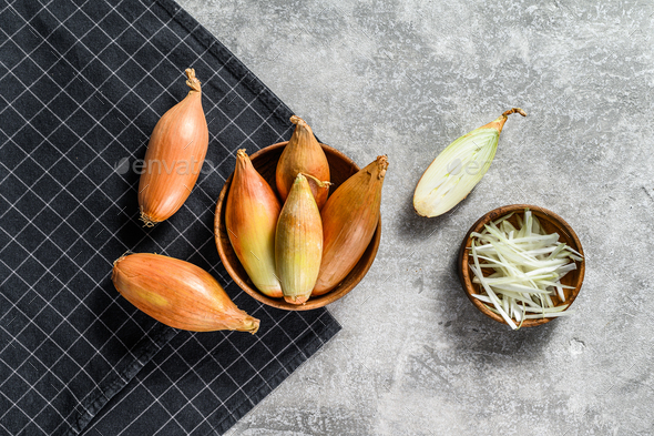 Yellow raw shallot onions, sliced and halved. Gray background. Top view ...
