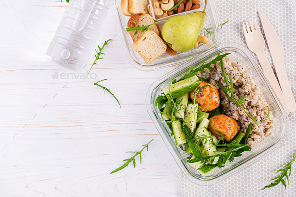 Lunch box filled with oatmeal, cucumber salad, and nuts, bread, pear ...