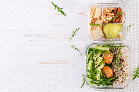 Lunch box filled with oatmeal, cucumber salad, and nuts, bread, pear ...