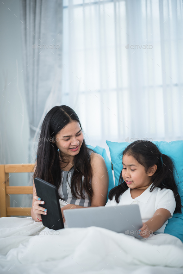 children and girl sisters having fun to watching online video on laptop ...