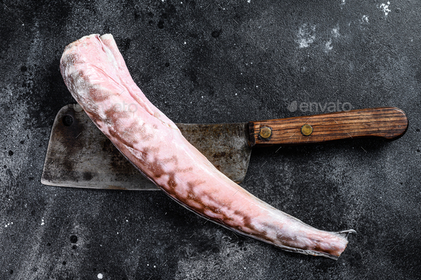 Raw king klip, congrio fish on a cleaver. Black background. Top view ...