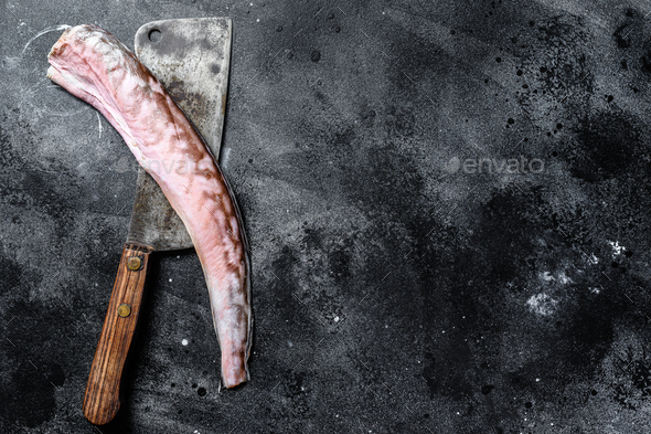 Raw king klip, congrio fish on a cleaver. Black background. Top view ...