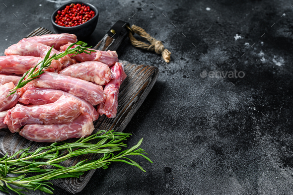 Raw chicken neck meat on a cutting board. Black background. Top view ...