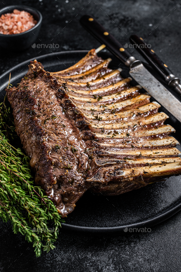 BBQ Grilled rack of Lamb mutton Ribs Chops on plate with thyme. Black ...