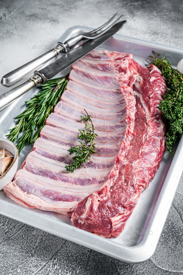 Raw uncooked rack of mutton lamb ribs in baking dish. White background ...