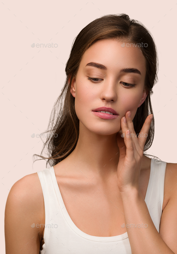 Beauty model woman with healthy natural make up clean skin touching her ...