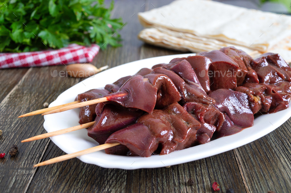 Pieces of raw pork liver on wooden skewers for cooking barbecue. Diet ...